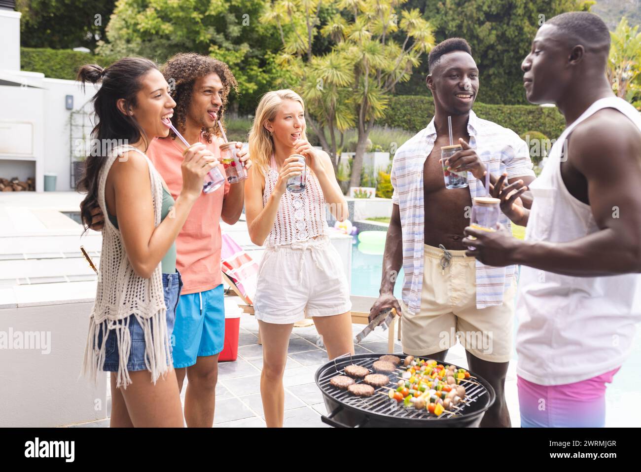 Diverse group of friends enjoys a barbecue party outdoors Stock Photo ...