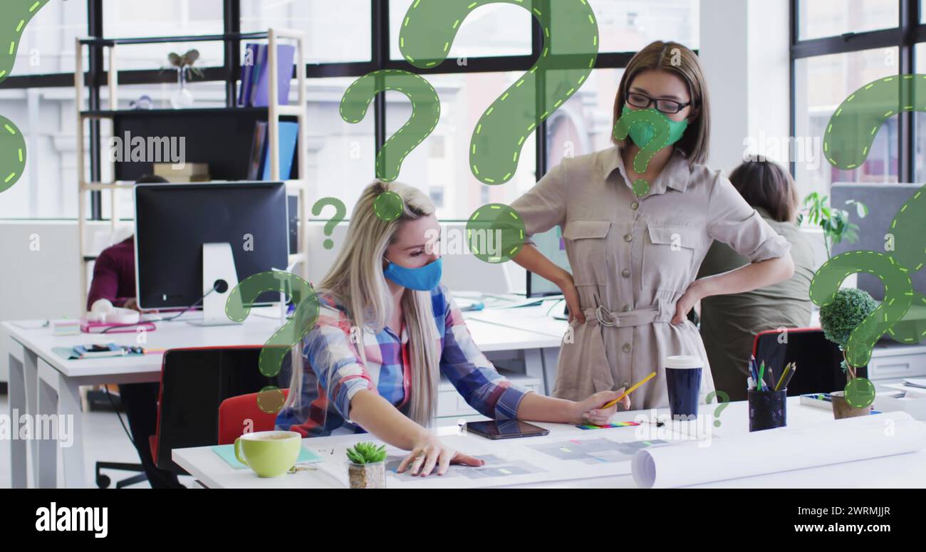 Image of question marks over diverse businesswomen wearing face masks ...