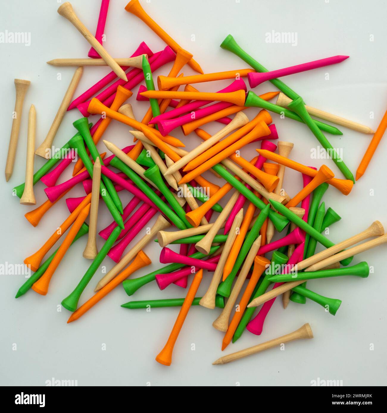 A pile of wood golf tees of different colours on a white surface Stock ...
