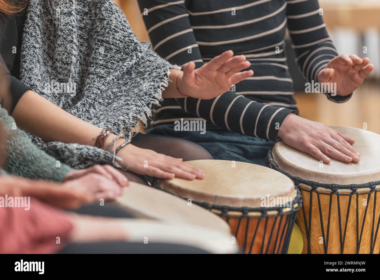 Women playing on the djembe drums during music therapy, drumming ...