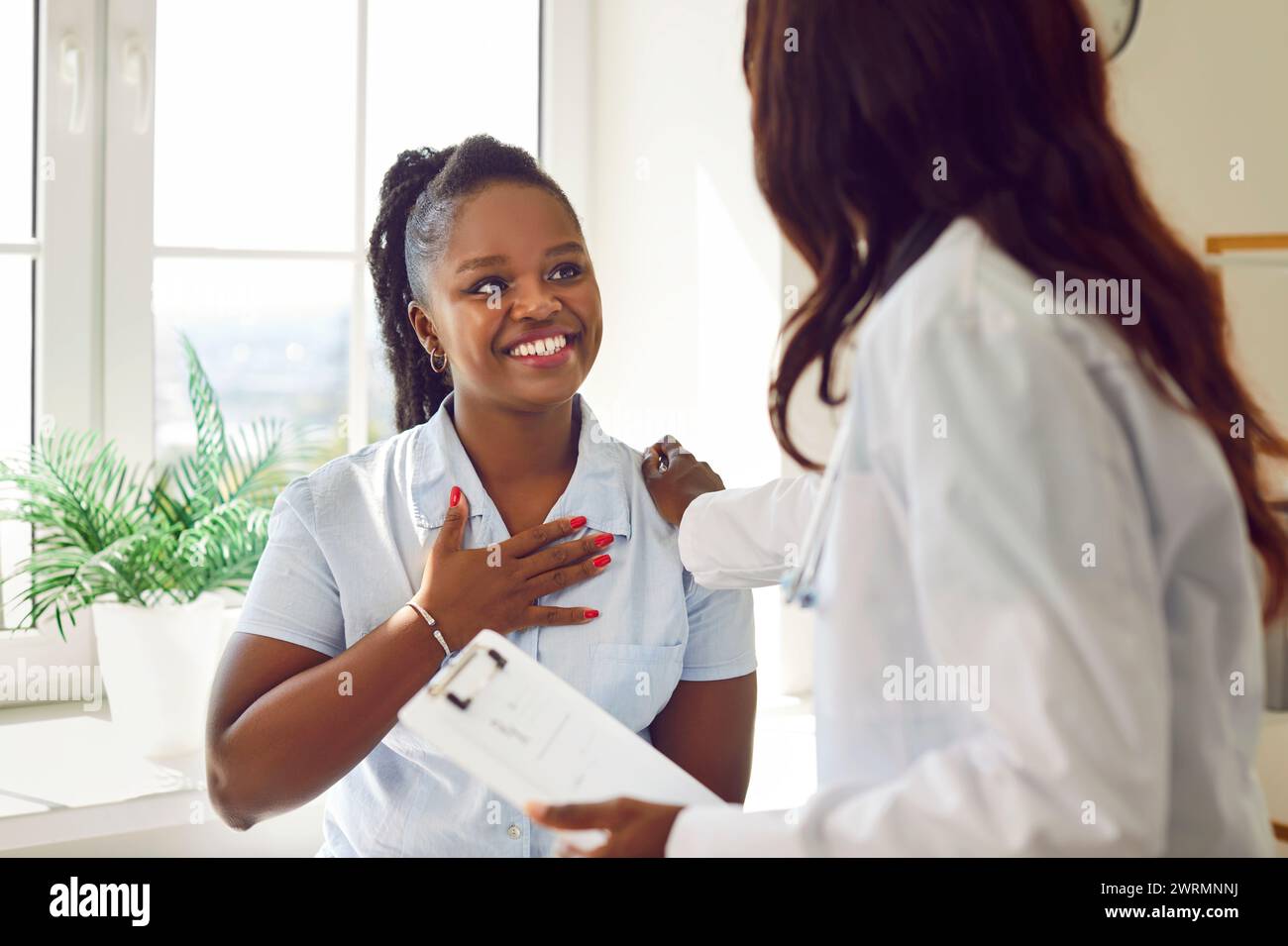 Black Female Doctor Talking with Patient in Hospital Office Stock Photo ...