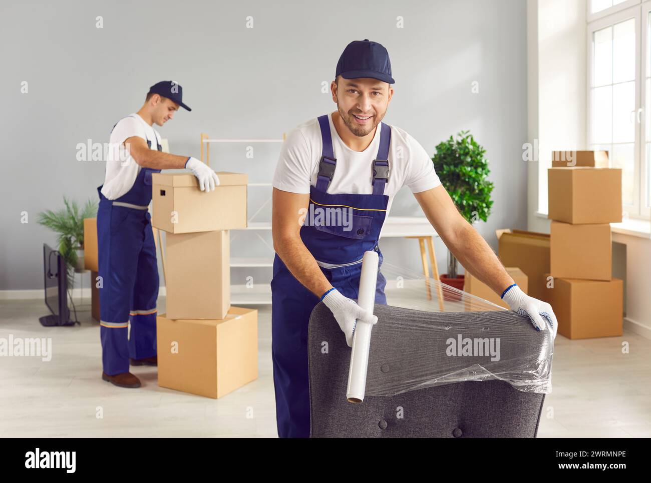 Movers male professional team in overalls loading, packing and ...