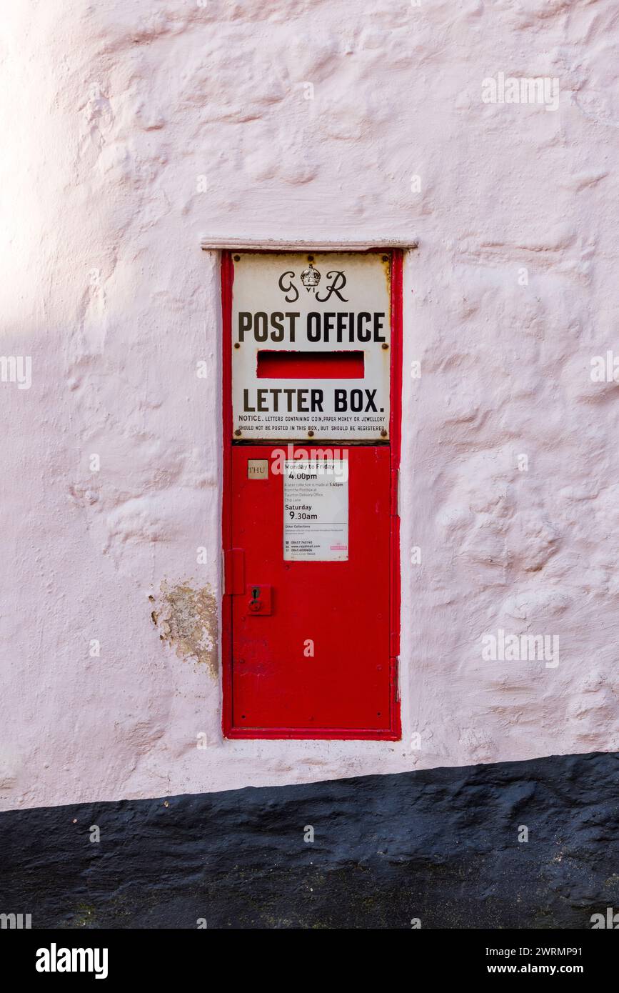 An old traditional red letterbox in the wall of a cottage in the rural ...