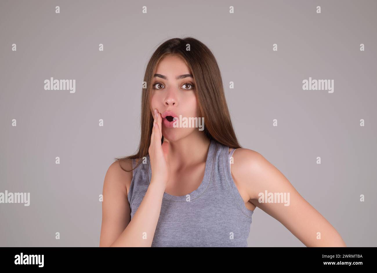 Shocked face of woman shouting WOW, isolated on studio background with ...