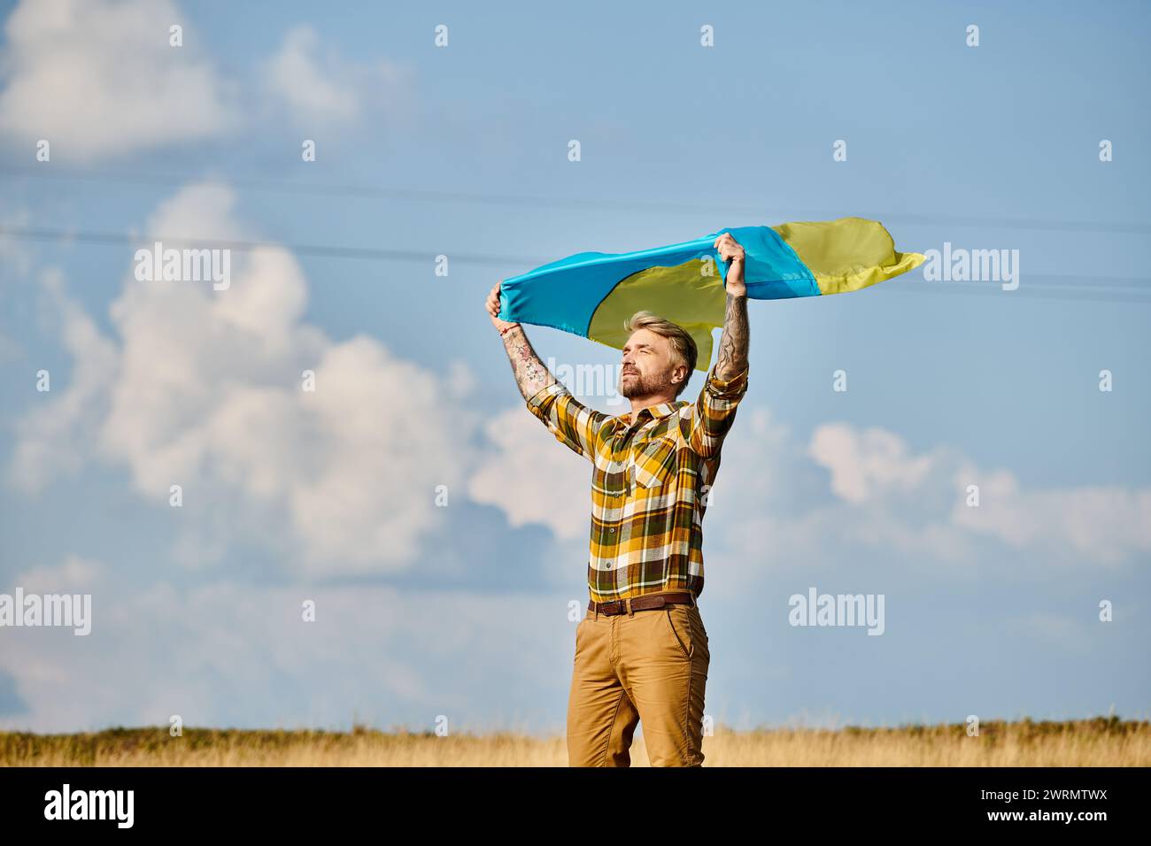 appealing Ukrainian man in casual attire posing with national flag ...