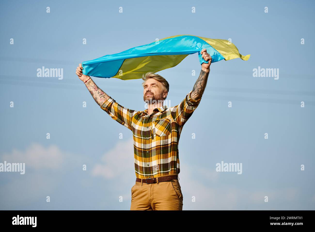 appealing Ukrainian man in casual attire posing with national flag ...
