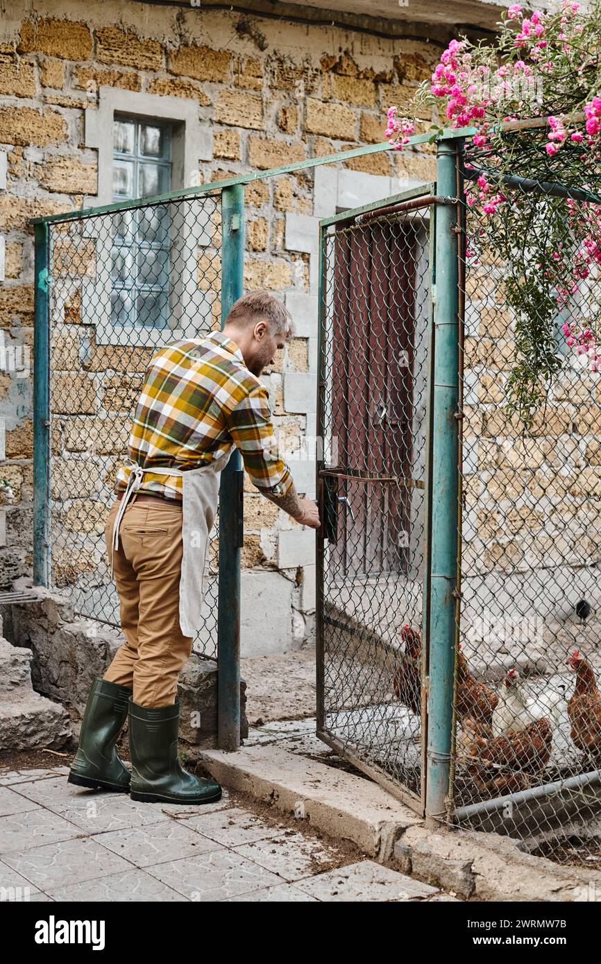 handsome bearded man in casual attire with tattoos opening enclosure ...