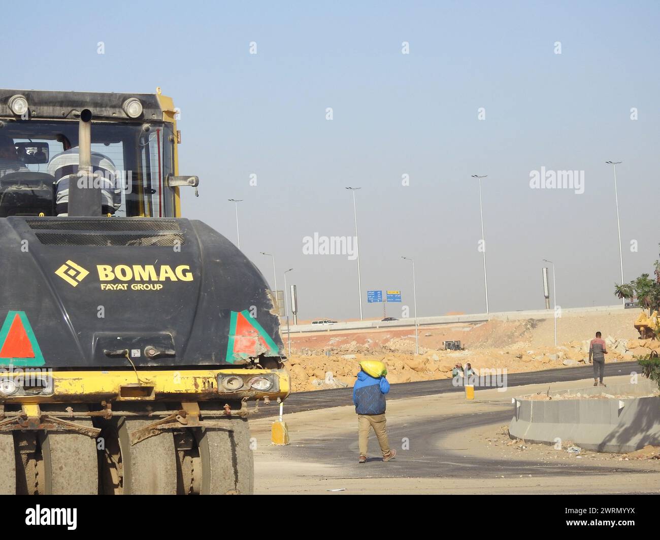 Cairo, Egypt, March 2 2024: process of paving a road and making asphalt ...