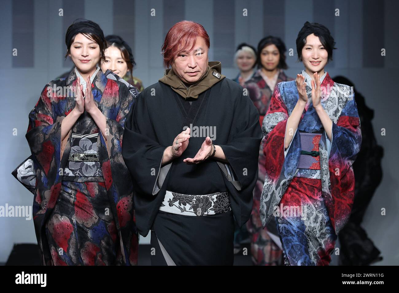 Tokyo, Japan. 13th Mar, 2024. Fashion designer Jotaro Saito (C) appears at the end of his runway ...