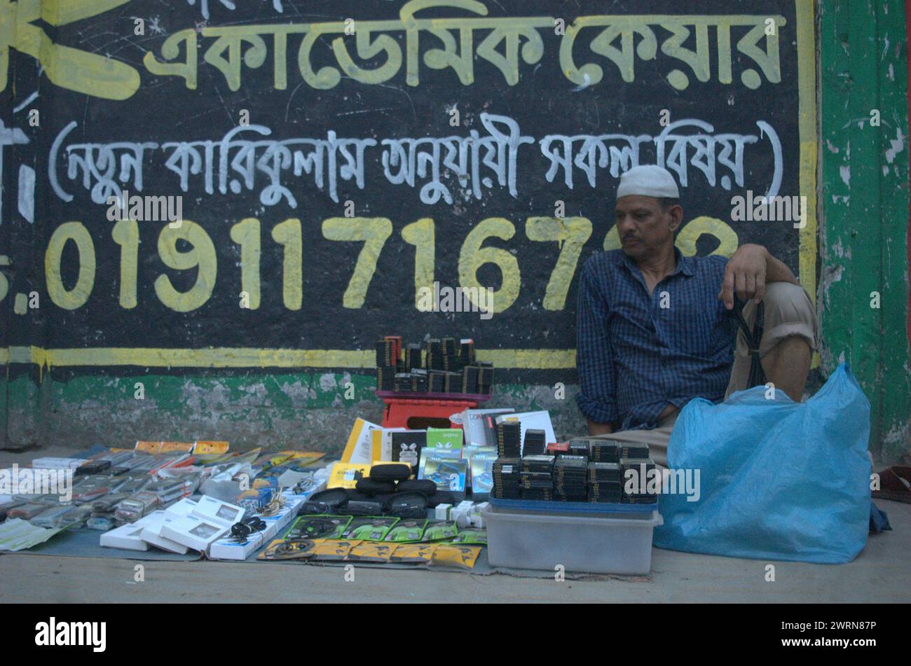 Dhaka, Bangladesh. 14th Mar, 2024. A vendor waits for customers as he sells second-hand ...