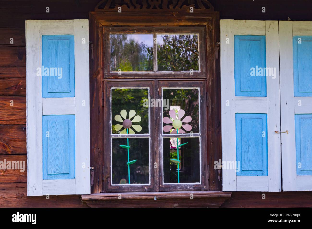 A window of an old country house with wooden shutters and flowers ...