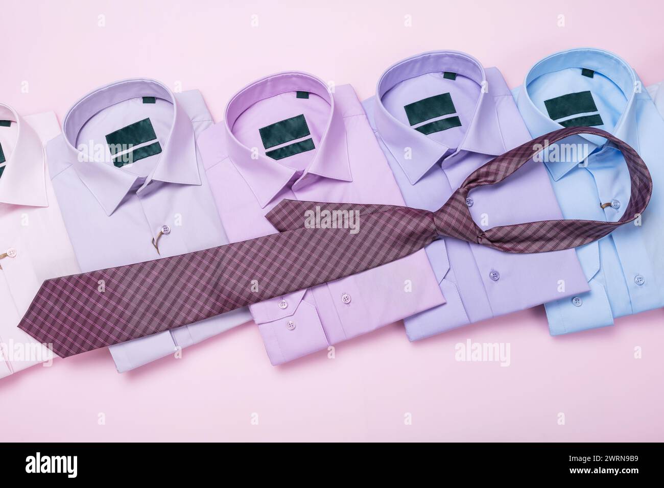 Multi-colored men's shirts and tie on a pink background, concept on the ...