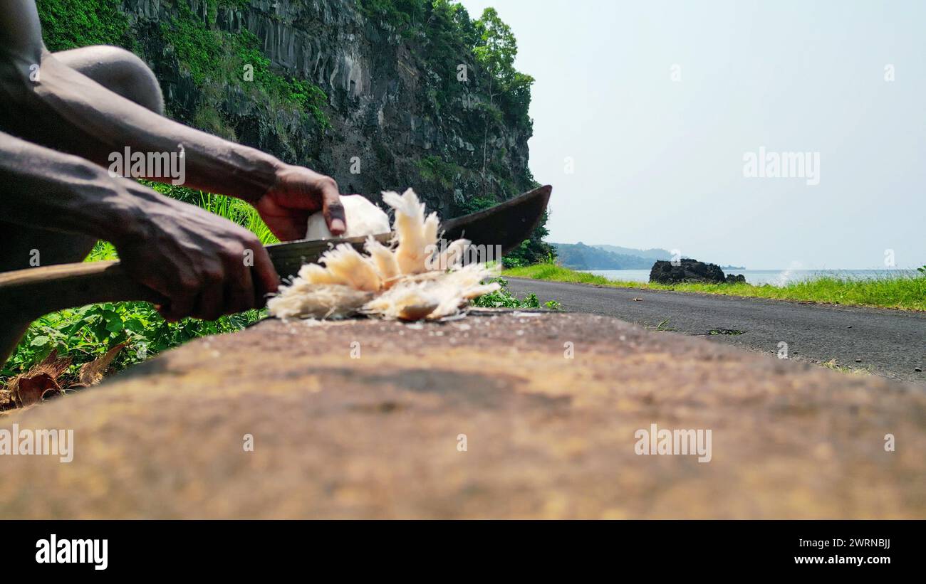 View of an African man with a machete cutting a coconut, with Santa ...