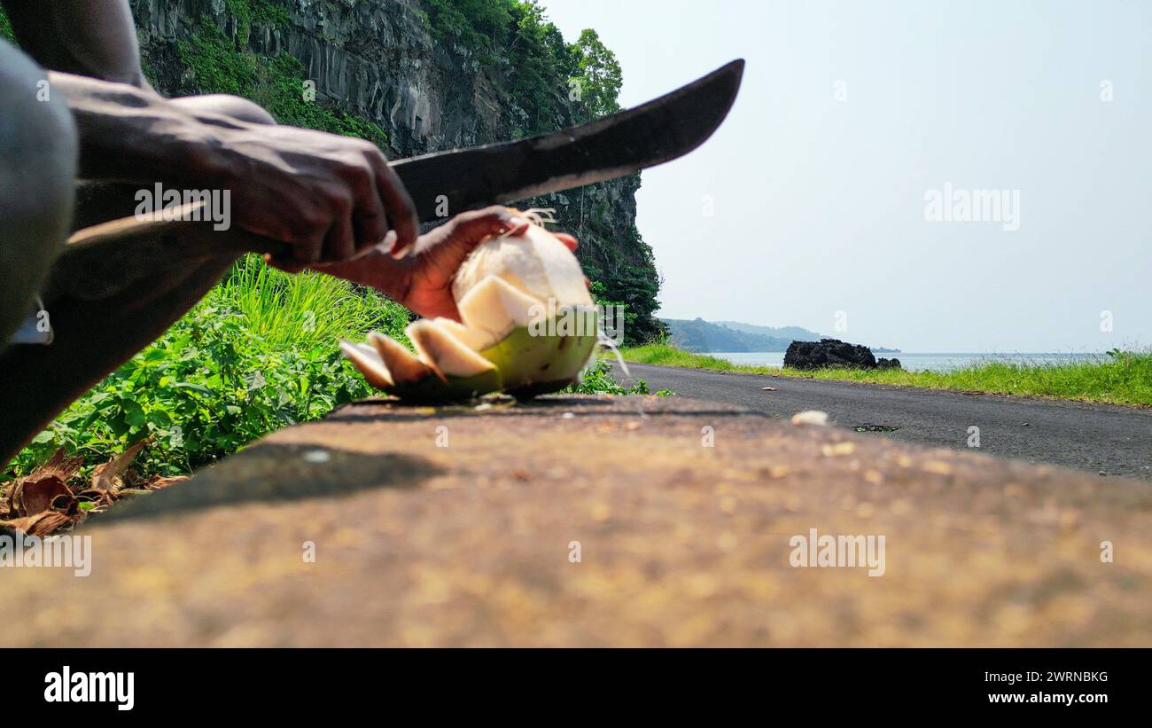View of an African man with a machete cutting a coconut, with Santa ...