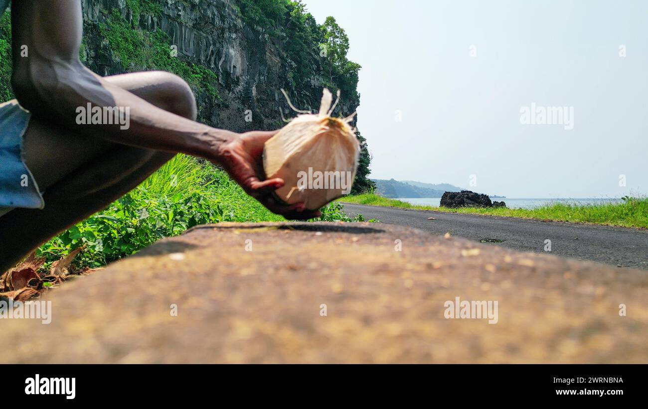 View of an African man with a machete cutting a coconut, with Santa ...