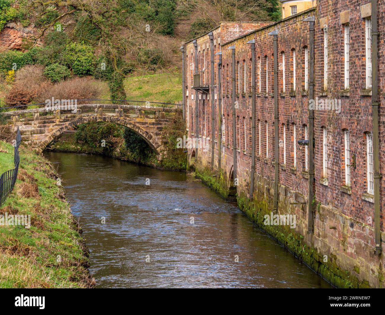 Packhorse Bridge crossing the river Bollin with Quarry Bank Mill to the ...