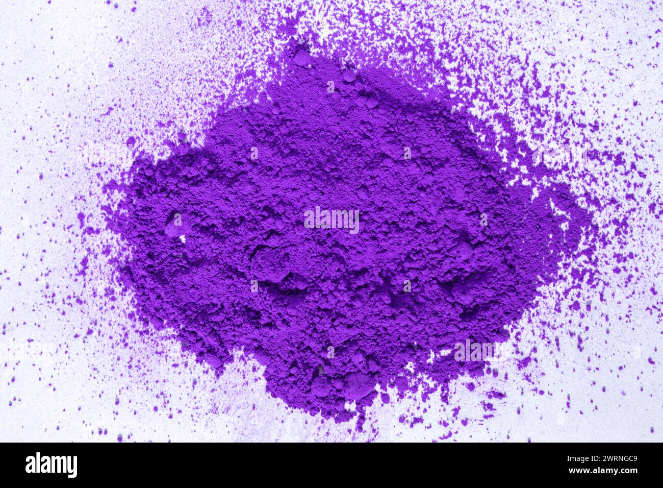 a bunch of dry natural purple pigment on a white background macro ...