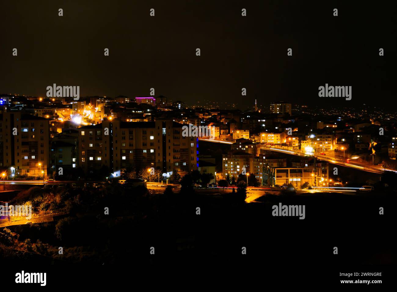 Residential buildings with illuminated windows, fast moving cars: night ...