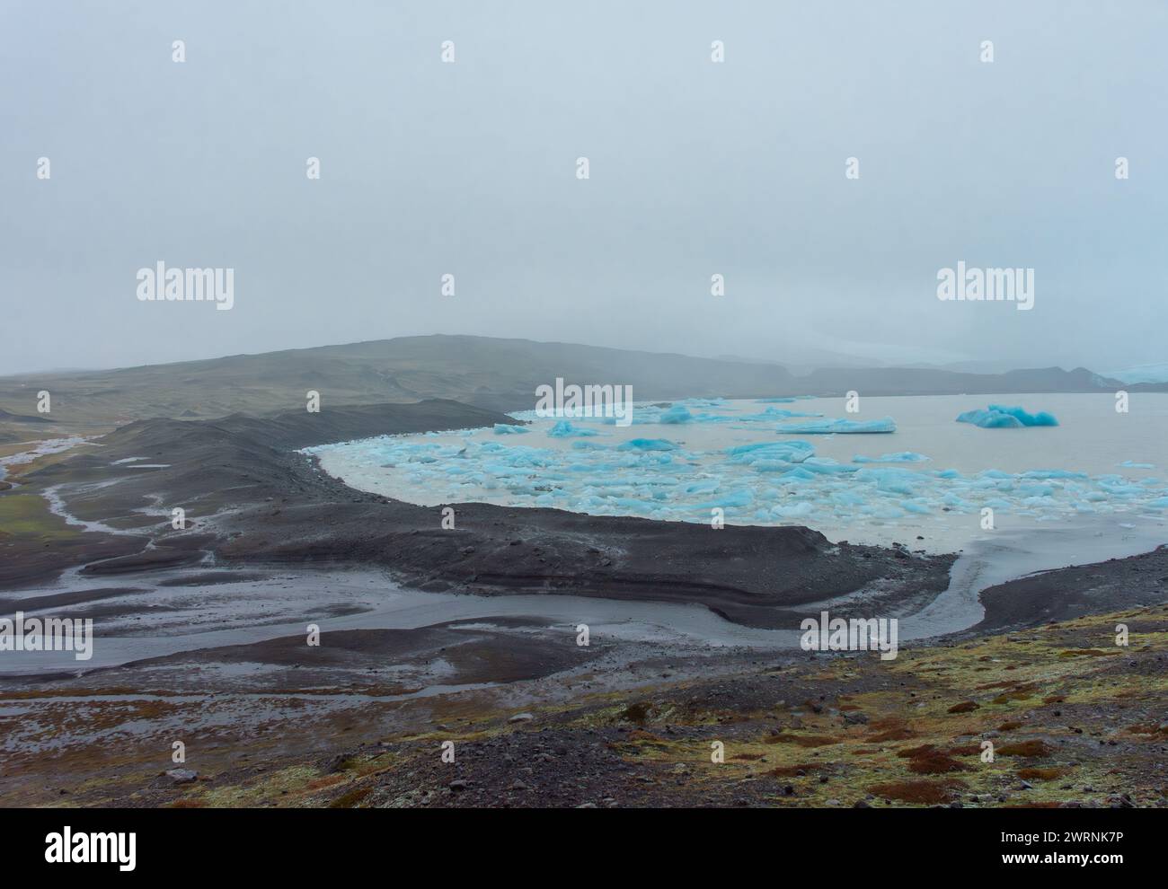 Icebergs from the melting Fjallsjokull Glacier under the rain, Iceland ...