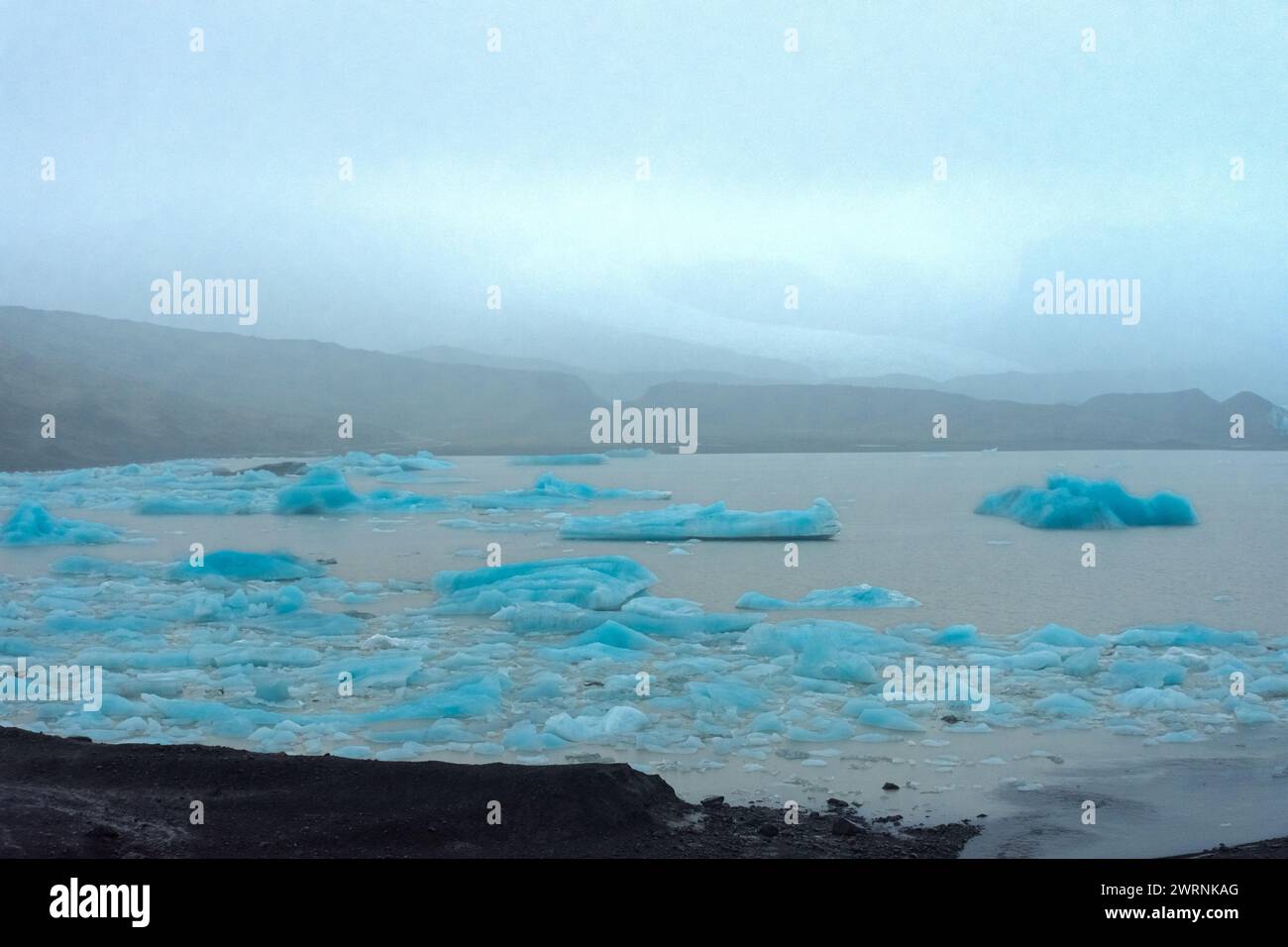 Icebergs from the melting Fjallsjokull Glacier under the rain, Iceland ...