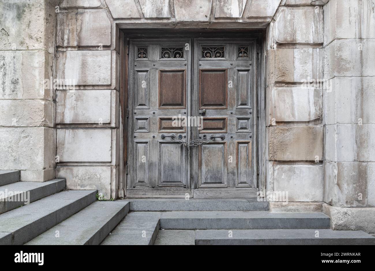 London, UK - Feb 27, 2024 - Chains locking an Entrance old wooden iron ...