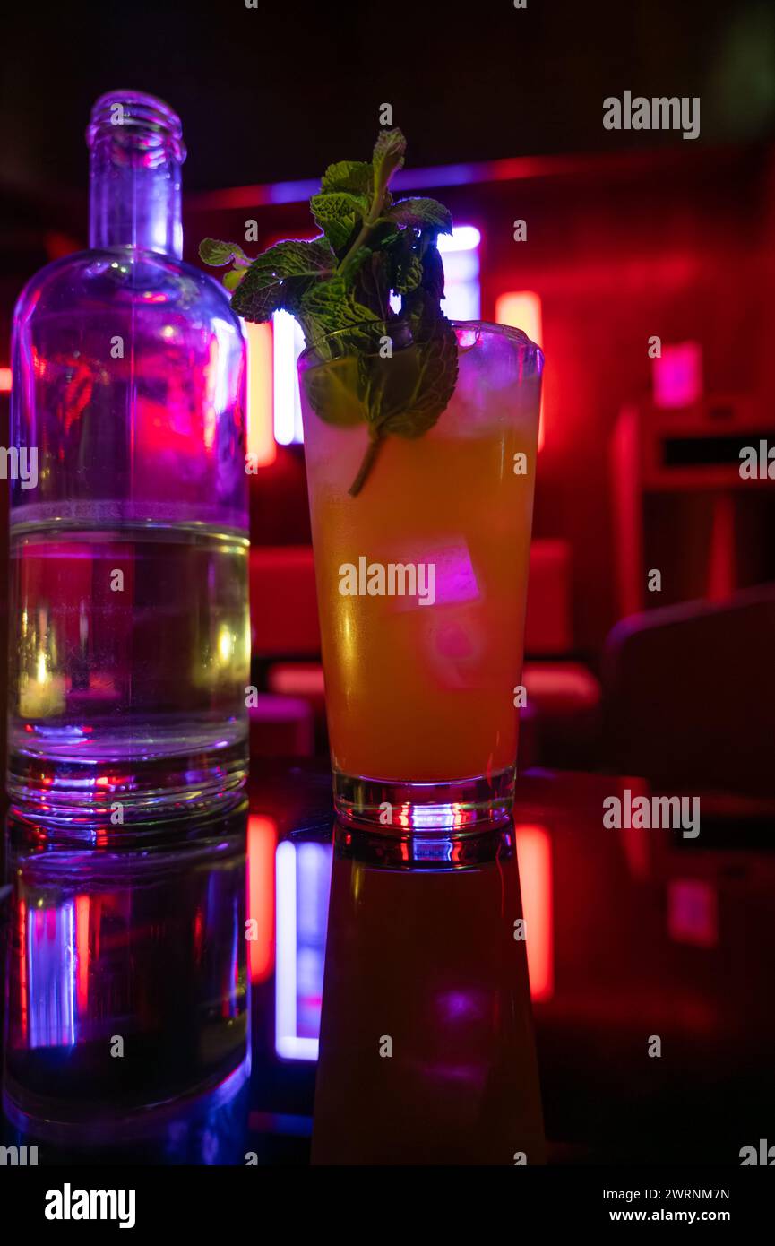 Whiskey and rum colorful cocktails served with ice cubes on black table ...