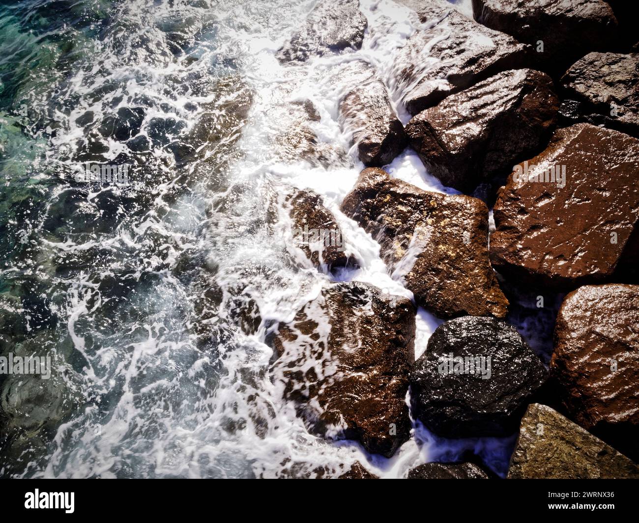 Rocky beach with waves crashing in and scattered rocks in the ocean ...
