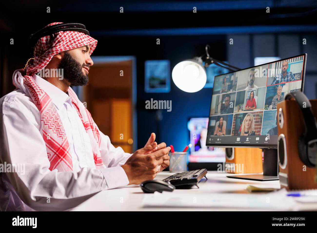 Confident Arab businessman in traditional clothing engaged in online ...