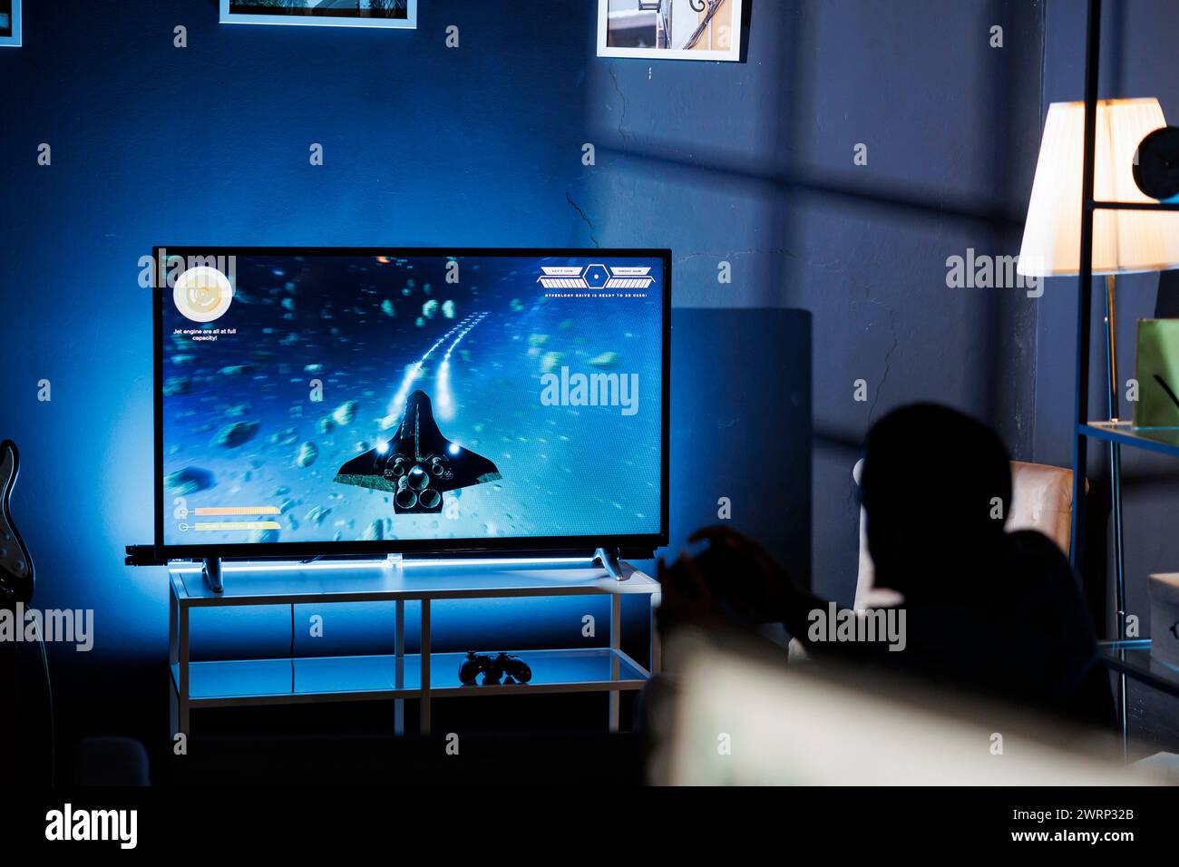 Young guy having fun with video games on television, connecting his console on tv in living room ...