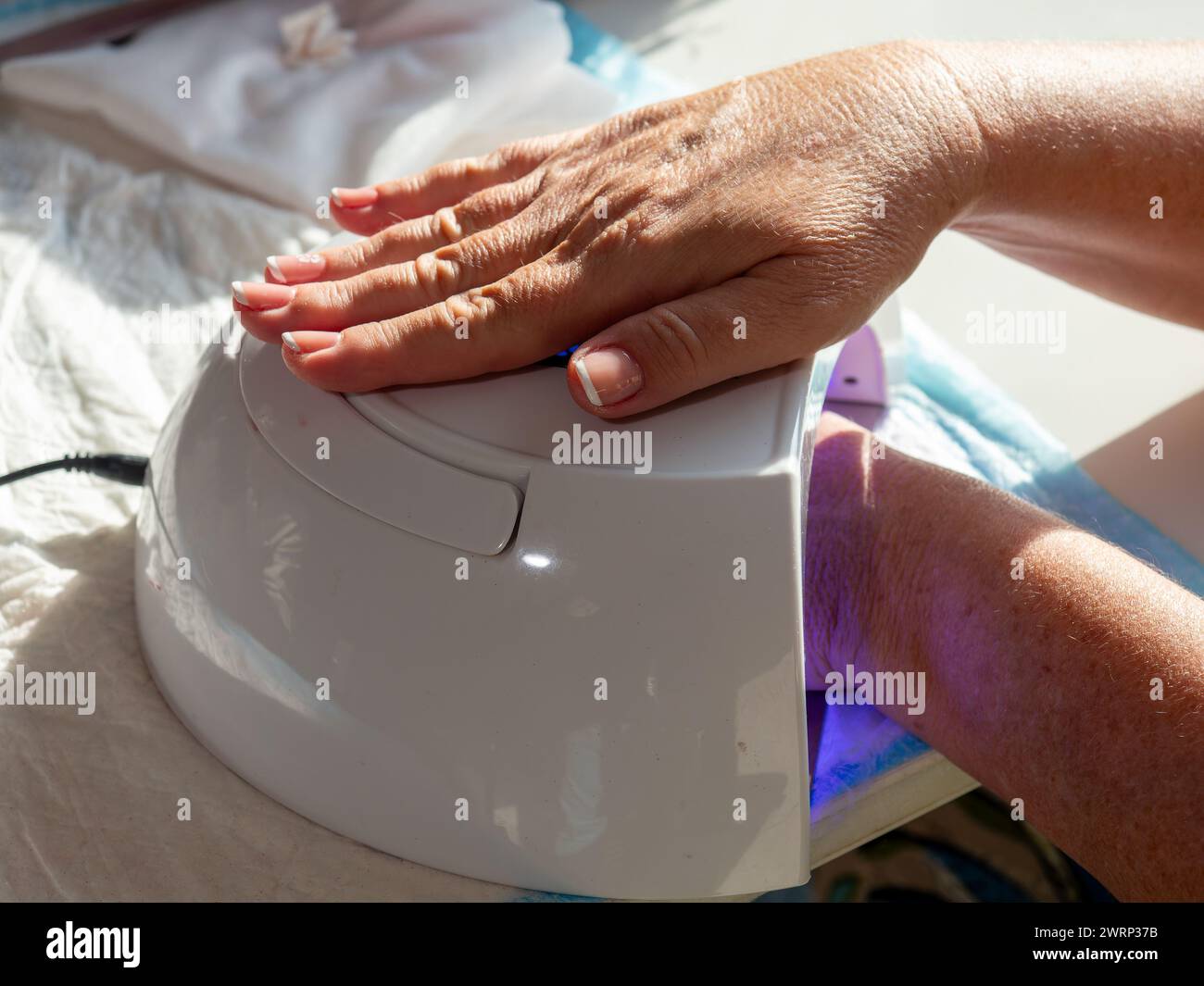 Hand inserted into gel lamp machine for permanent nail paints Stock ...