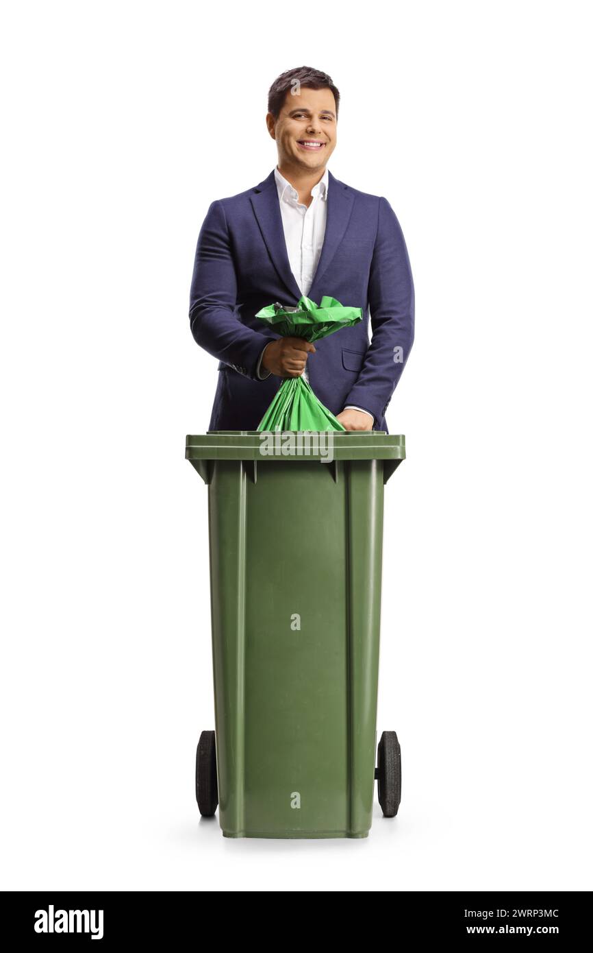 Full length portrait of a smiling young man throwing a waste bag in a ...