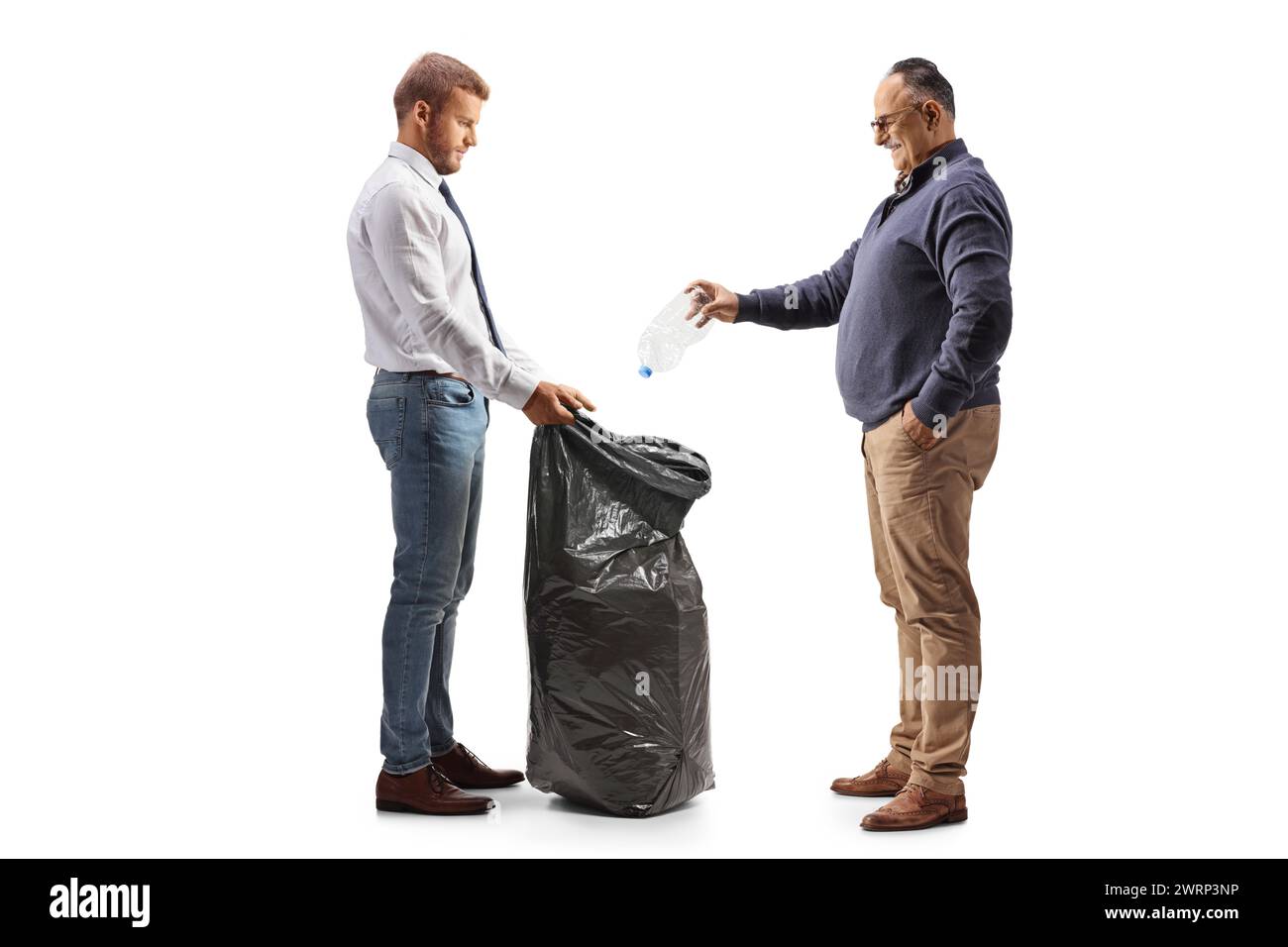 Mature man throwing a plastic bottle in a black waste bag held by a ...