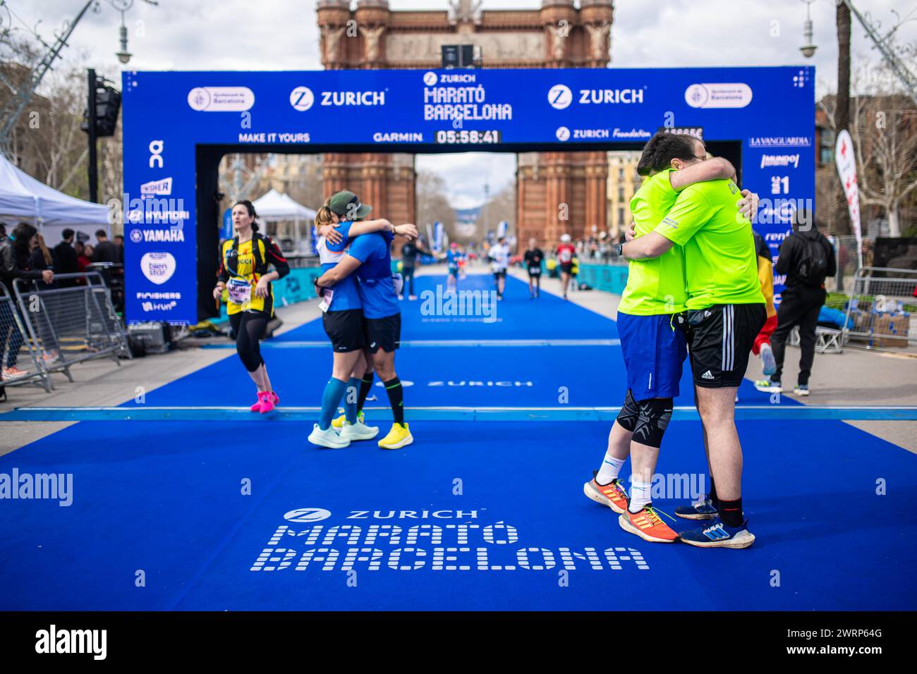 Runners happily reaching the finish line in the Barcelona Marathon in ...