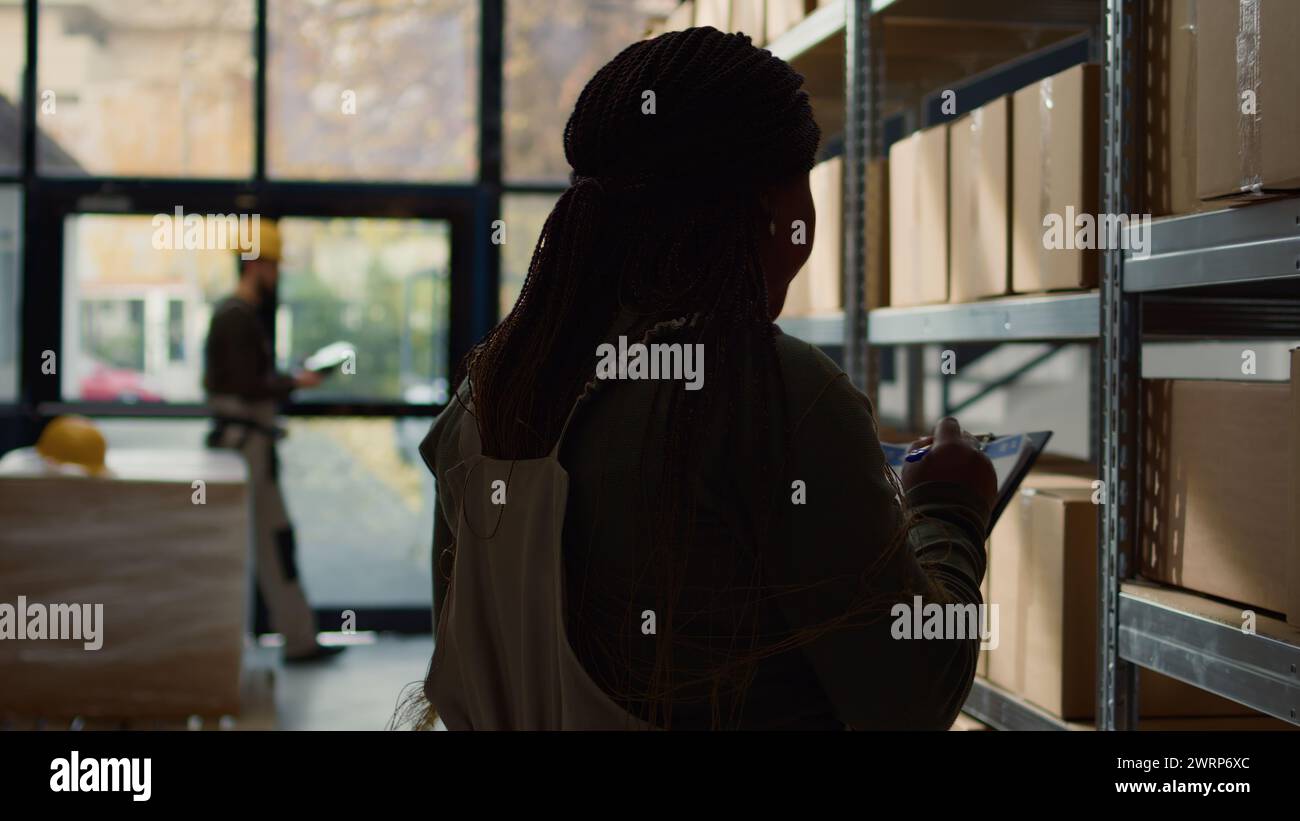 Tracking shot of inventory control manager inputing updated products ...