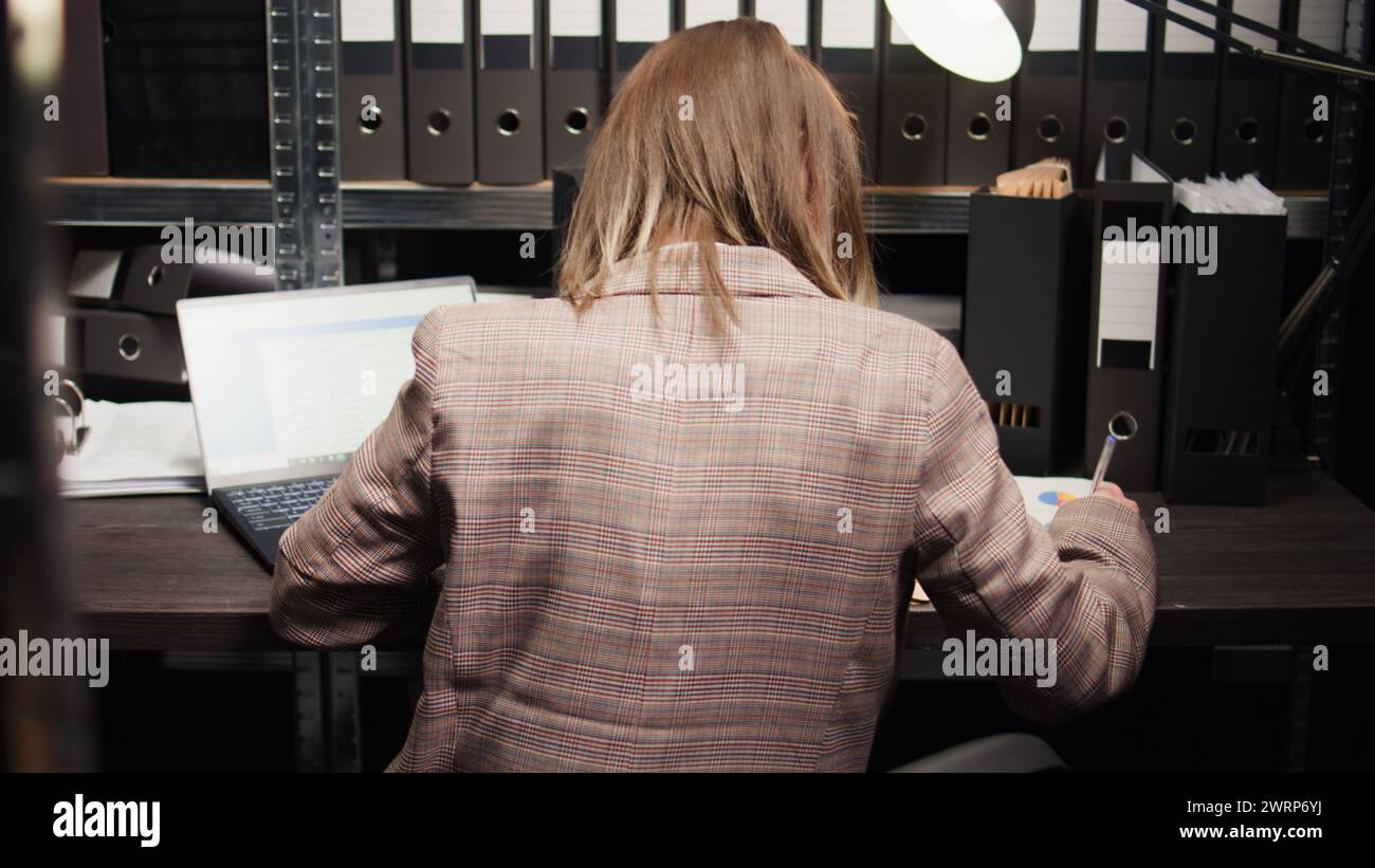 Female crime expert examining papers to put the pieces together and ...