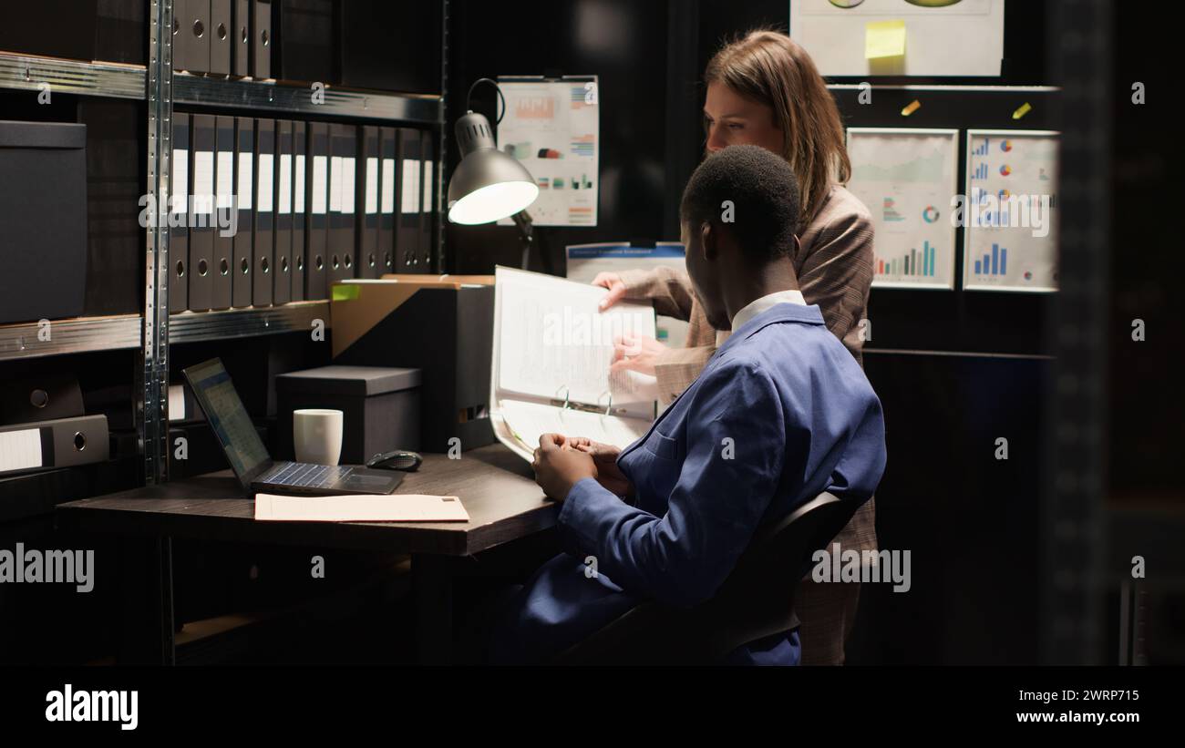 African american and caucasian investigators work together, examining ...