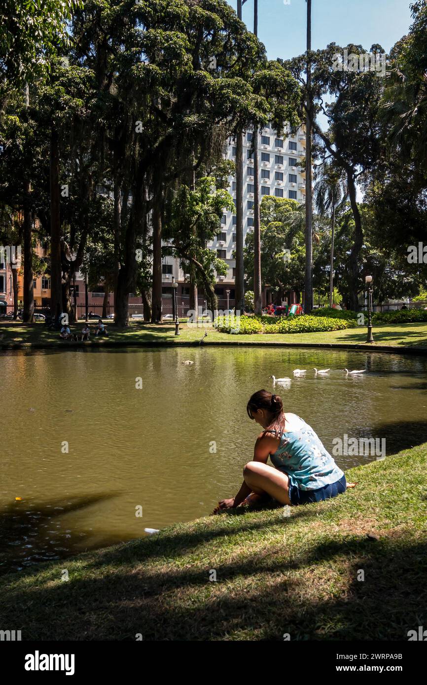 A young woman seated on the grass at the main lake on the west side of ...