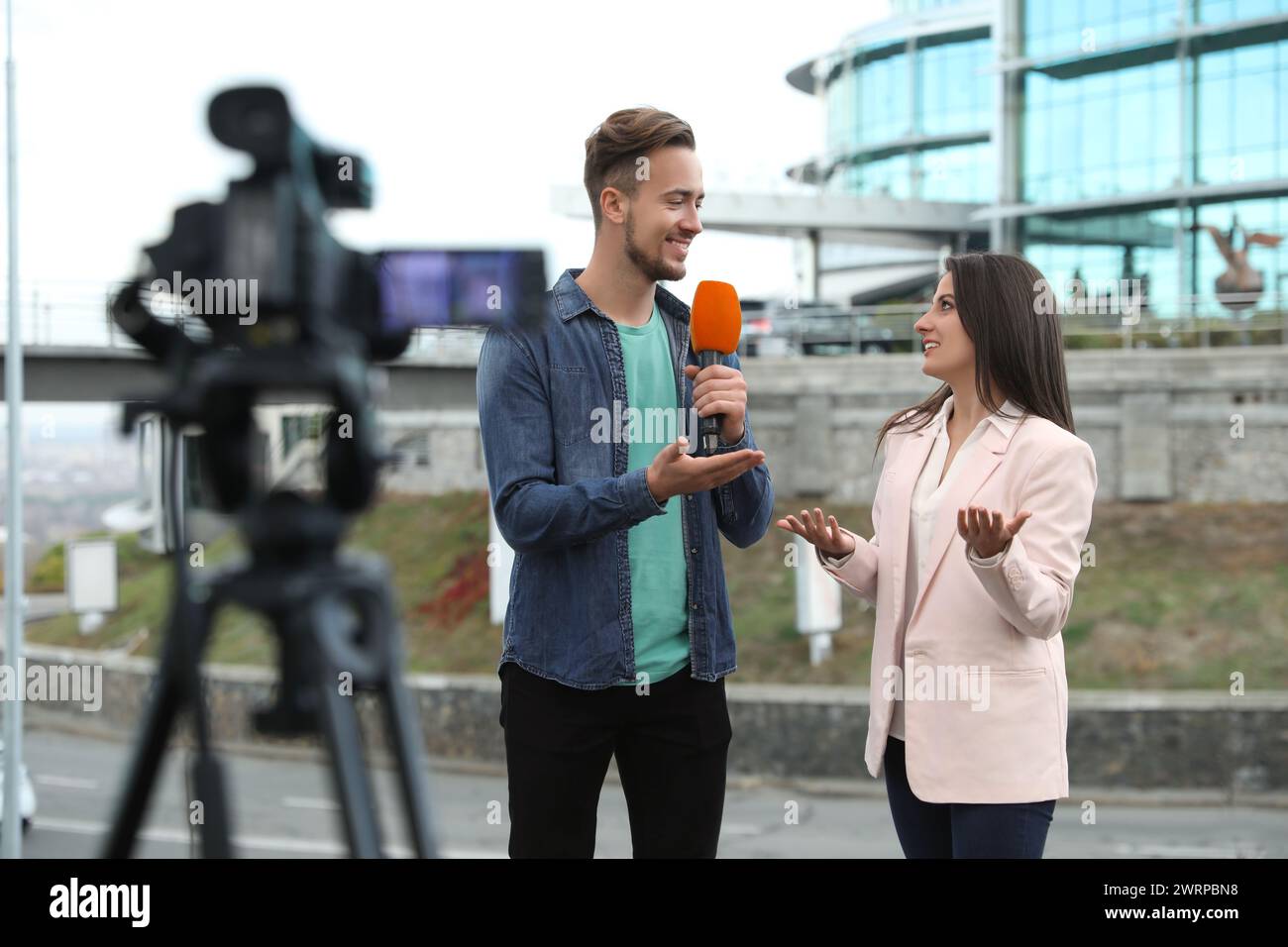 Young journalist interviewing businesswoman on city street Stock Photo ...