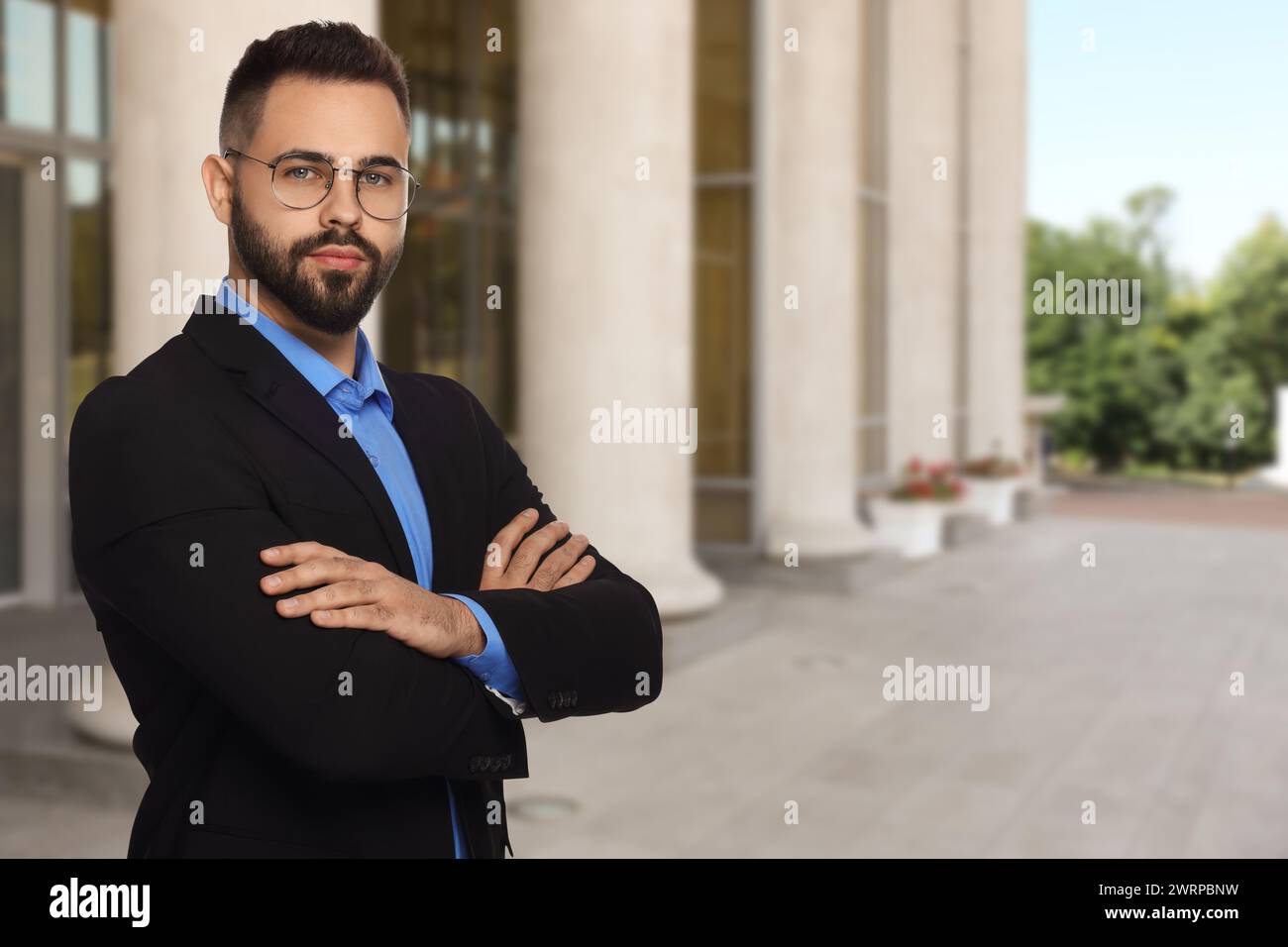 Successful lawyer in glasses near building outdoors, space for text ...