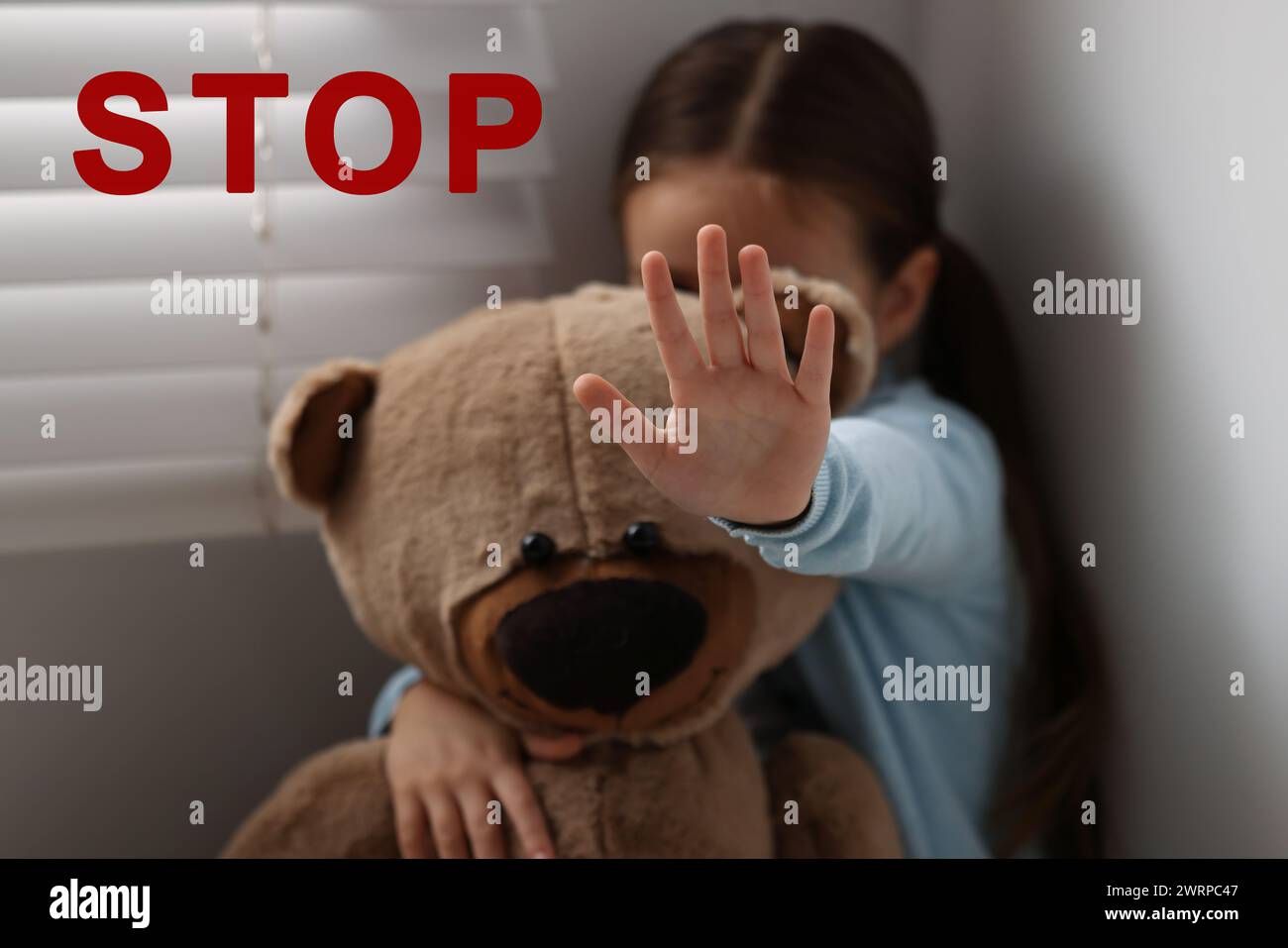 No child abuse. Little girl with teddy bear making stop gesture indoors ...
