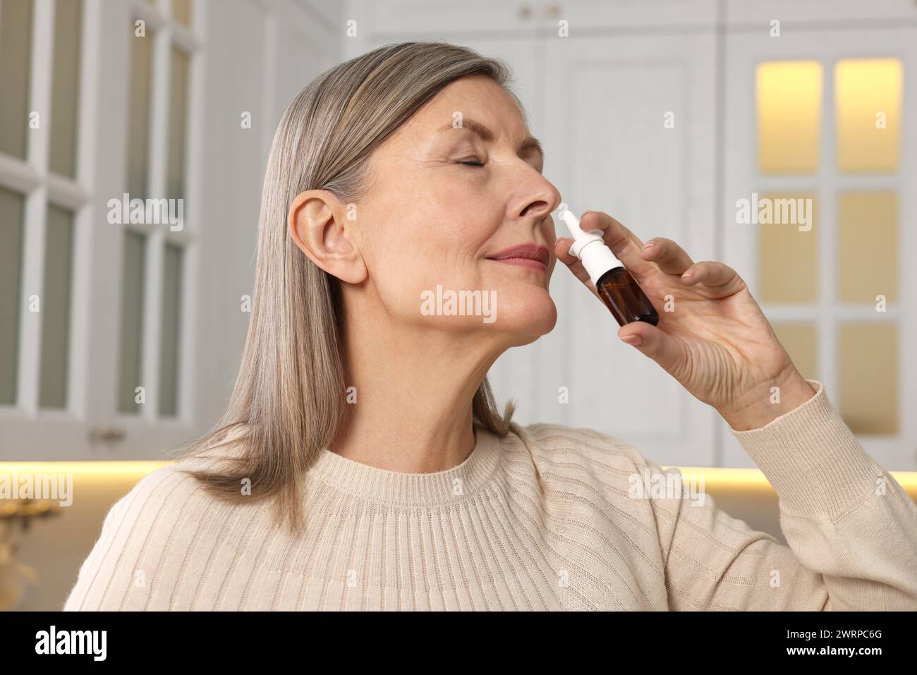 Medical drops. Woman using nasal spray indoors Stock Photo - Alamy