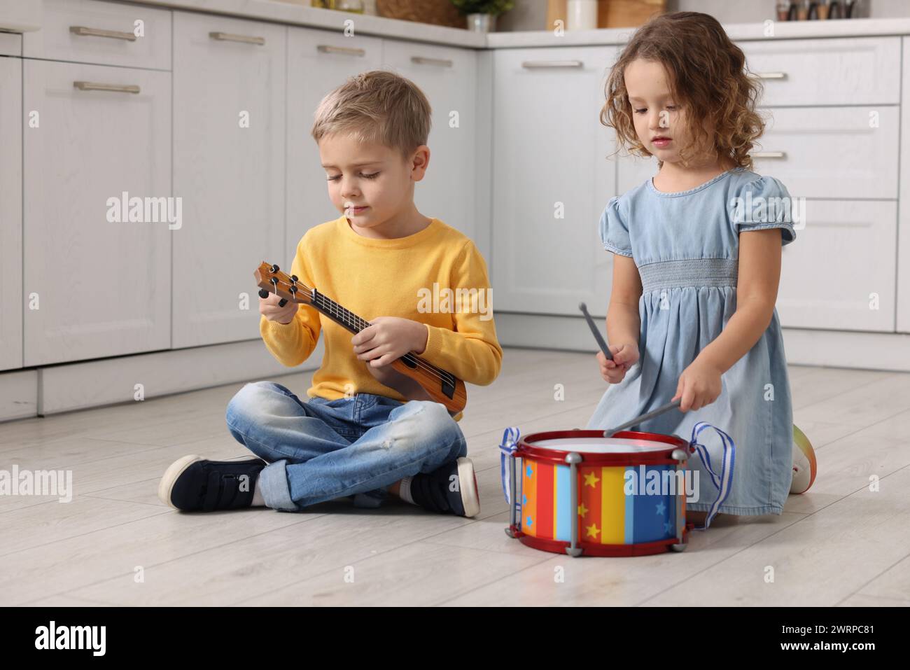 Little children playing toy musical instruments in kitchen Stock Photo ...