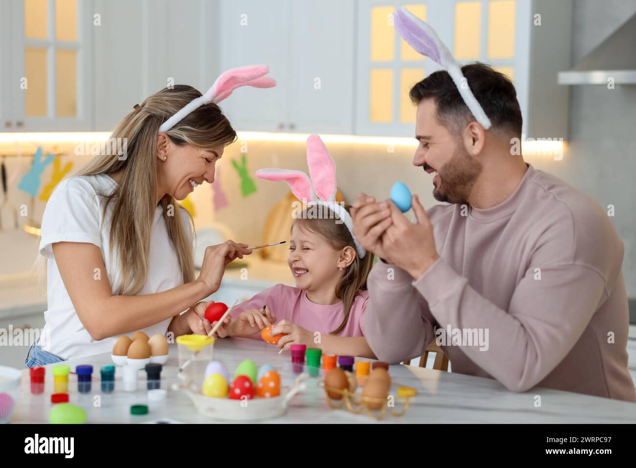 Easter celebration. Happy family with bunny ears having fun while ...