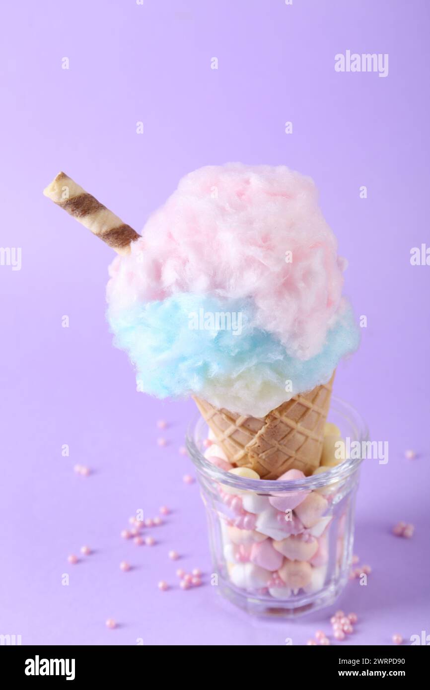 Sweet cotton candy in waffle cone on purple background, closeup Stock ...