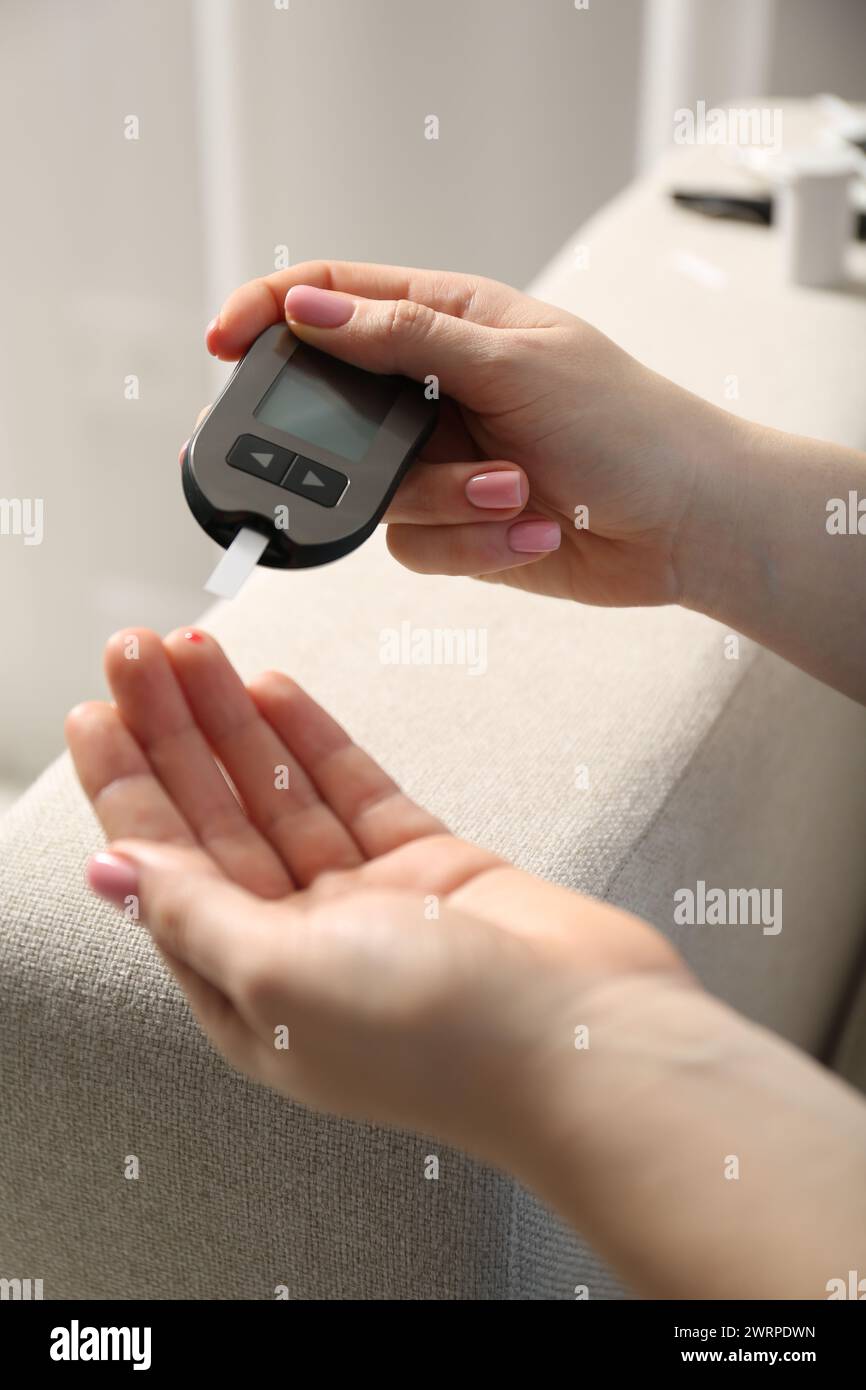 Diabetes. Woman checking blood sugar level with glucometer at home ...