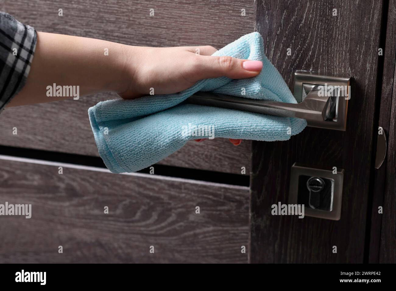 Woman wiping door handle with rag, closeup Stock Photo - Alamy