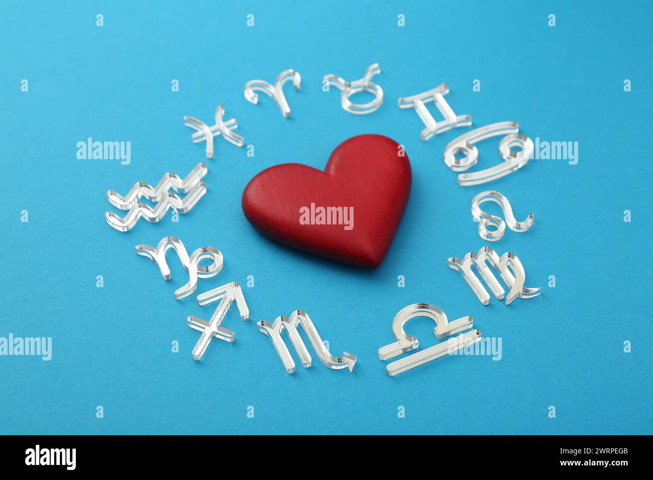 Zodiac signs and heart on light blue background, closeup Stock Photo ...