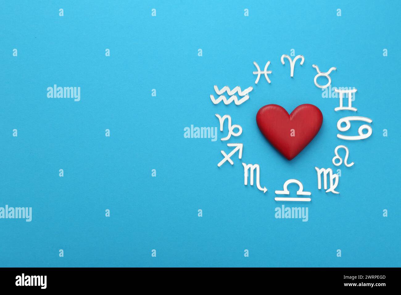 Zodiac signs and heart on light blue background, flat lay. Space for ...
