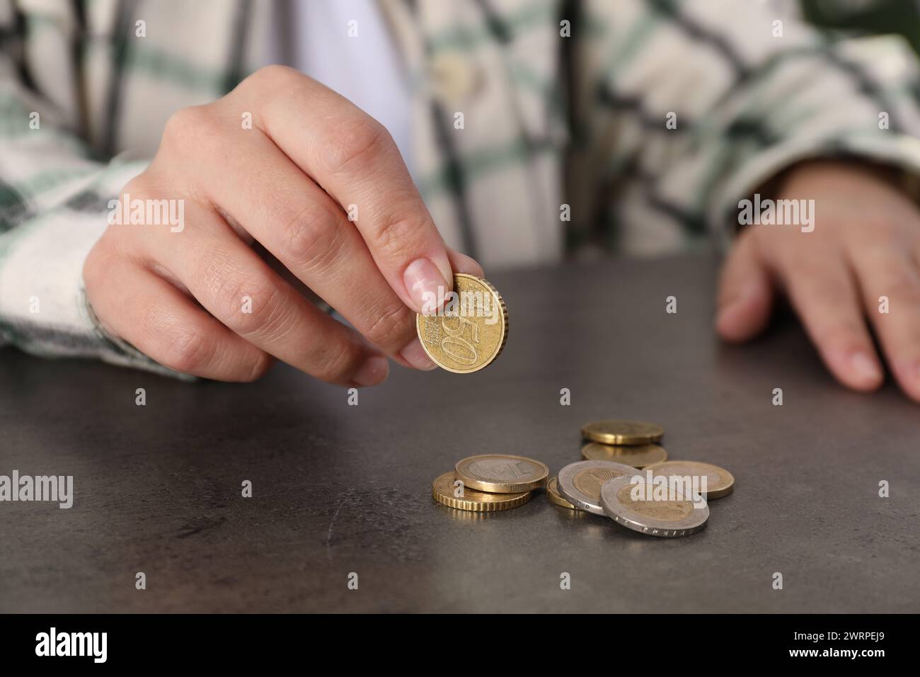 Poor woman counting coins at grey table, closeup Stock Photo - Alamy