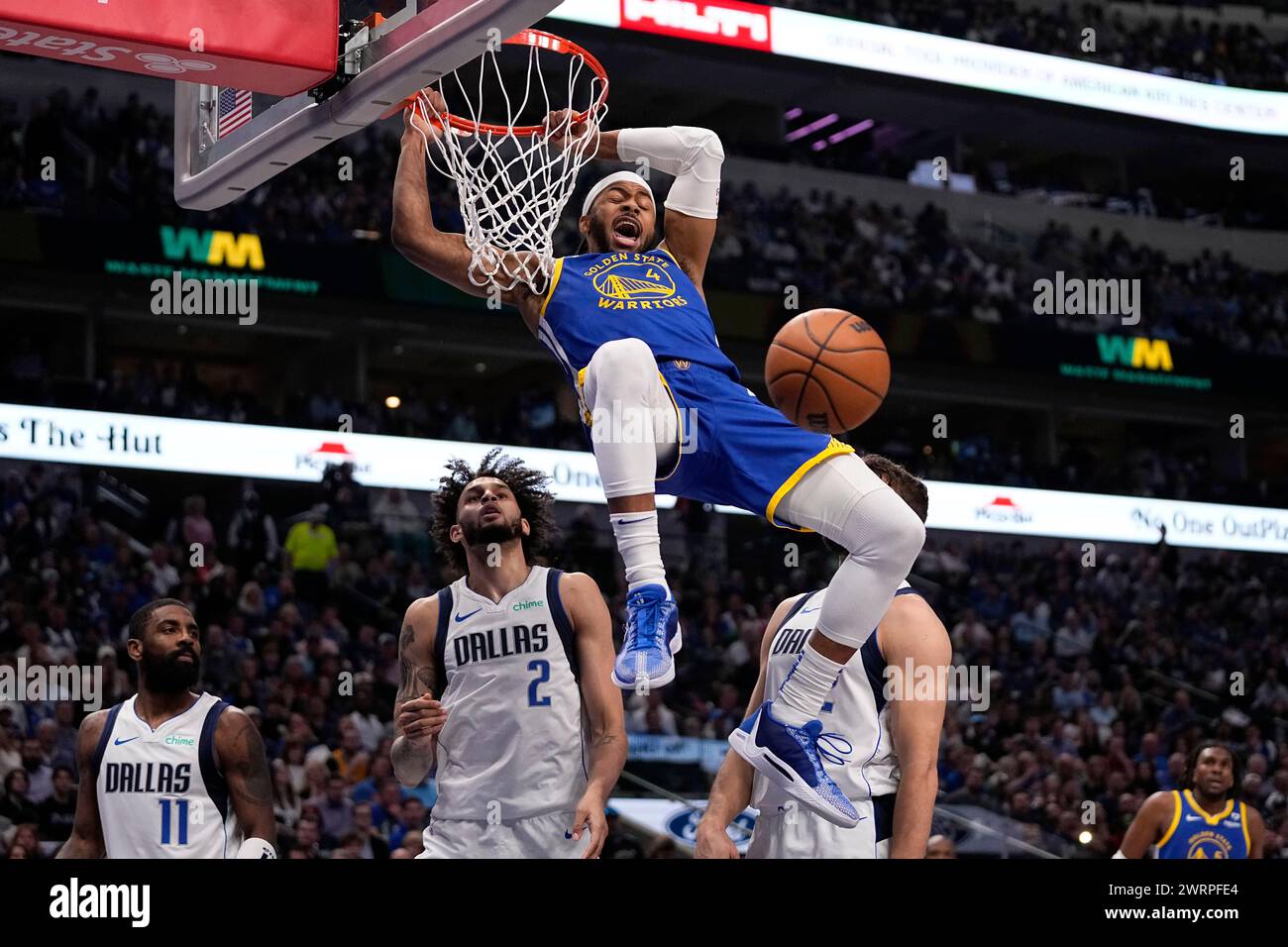 Golden State Warriors guard Moses Moody (4) dunks after getting past Dallas Mavericks' Kyrie ...